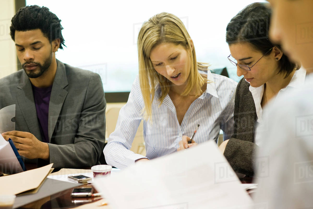 Executives discussing documents in meeting - Stock Photo - Dissolve