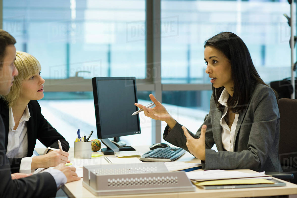 Female executive talking to colleagues - Stock Photo - Dissolve