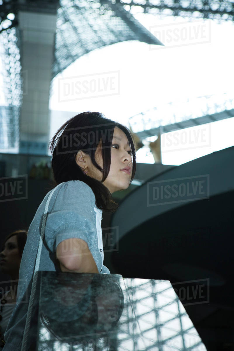 Young female leaning against railing, side view - Royalty-free Stock ...