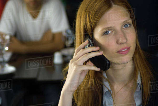 Woman holding cell phone to ear, smiling at camera - Royalty-free Stock ...