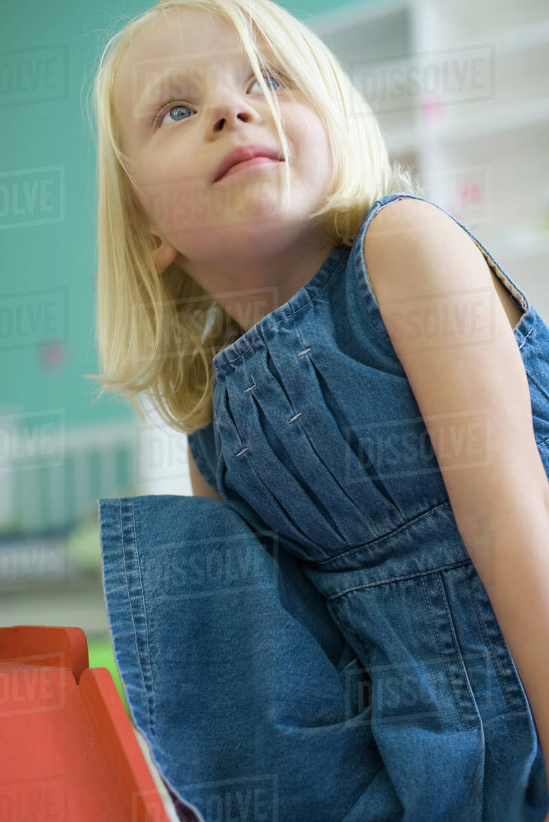 Little girl looking up in thought - Stock Photo - Dissolve