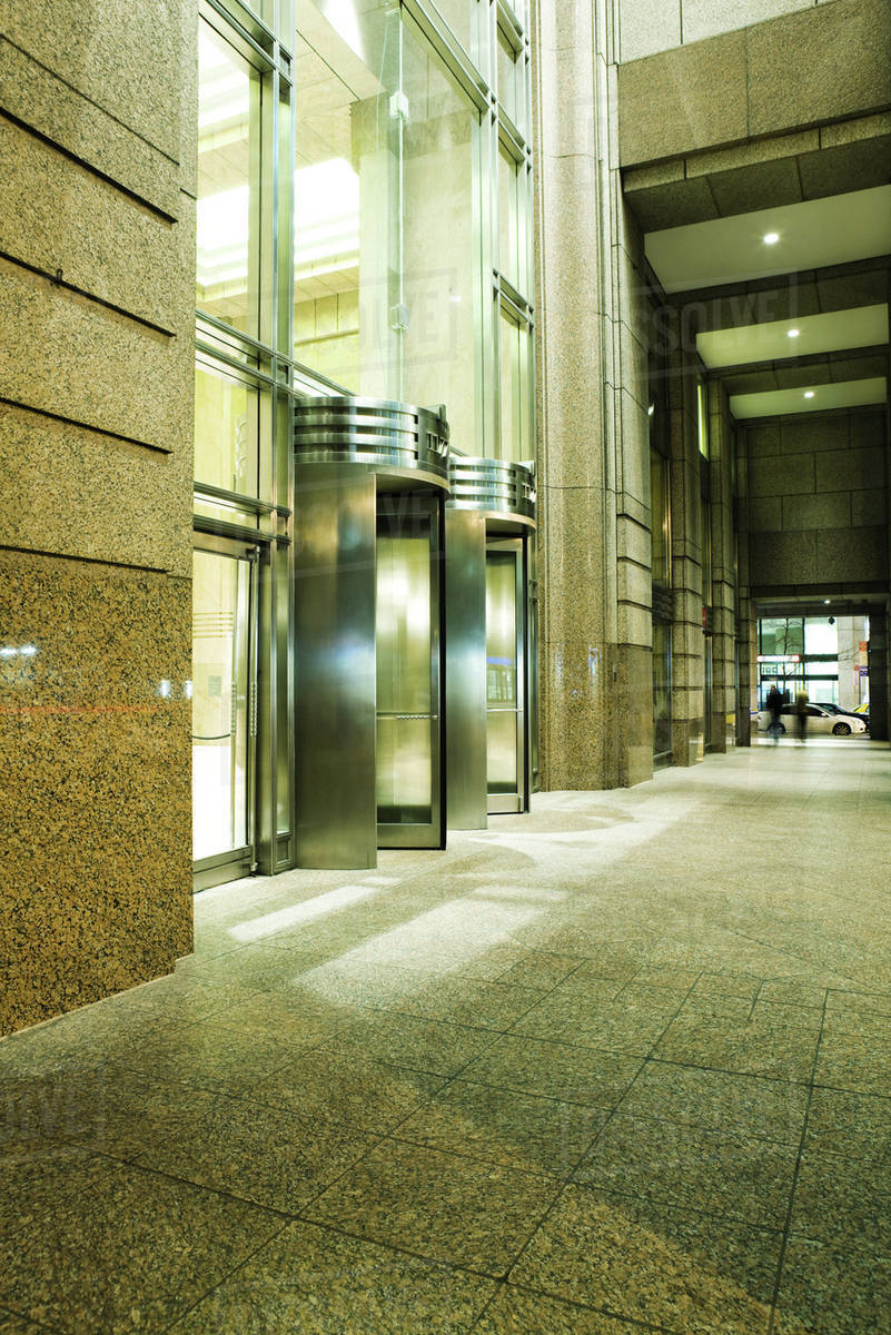 Revolving doors at high rise building entrance - Stock Photo - Dissolve