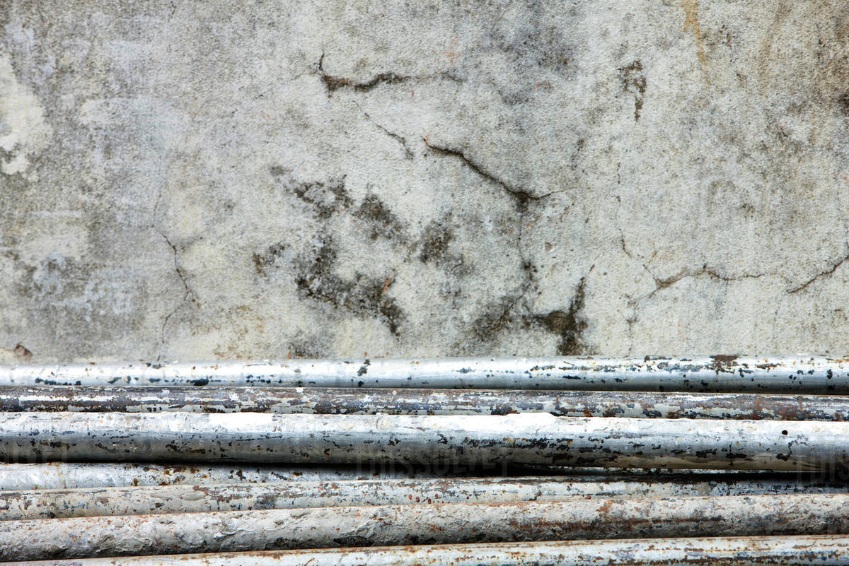 Metal piping stacked against wall - Royalty-free Stock Photo | Dissolve