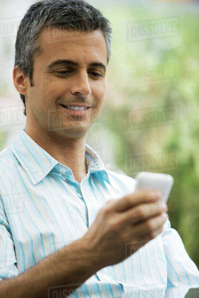Man text messaging with cell phone - Stock Photo - Dissolve