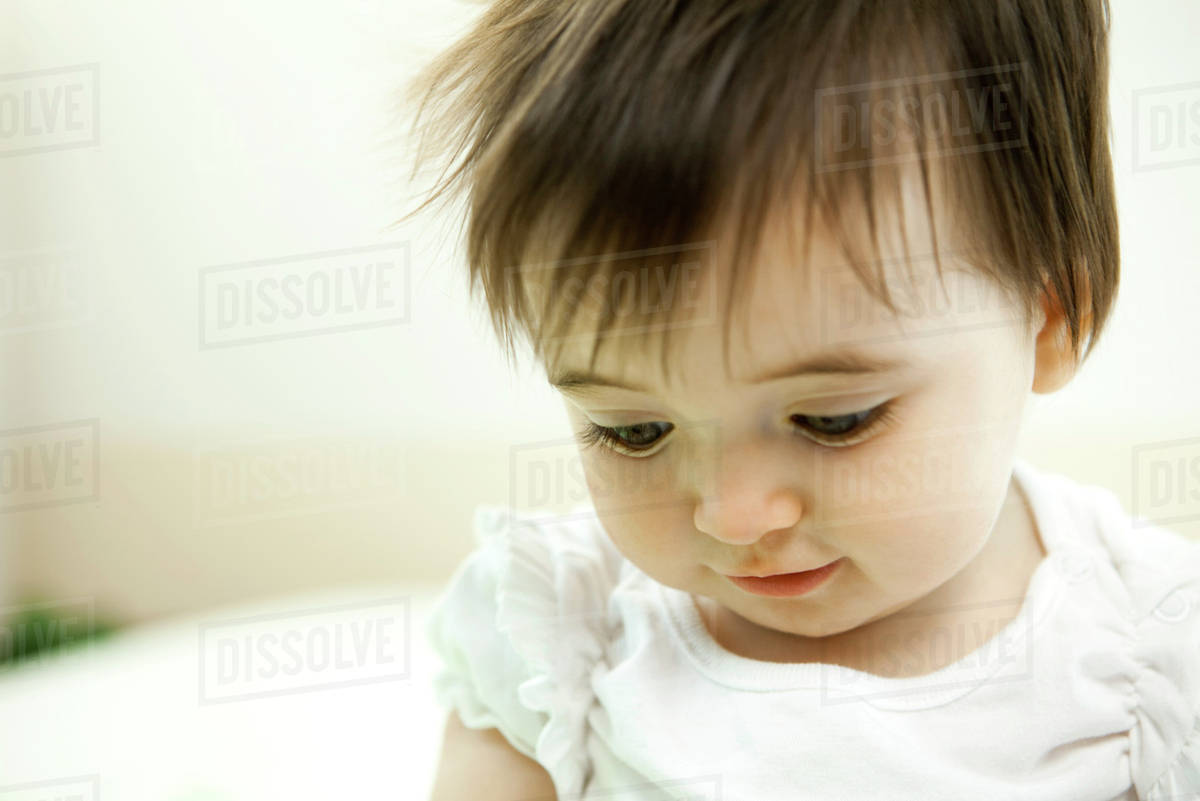 Baby girl looking down, portrait - Royalty-free Stock Photo | Dissolve
