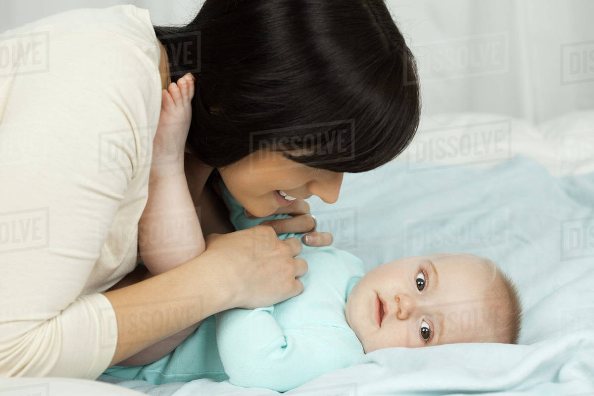 Mother cuddling baby - Stock Photo - Dissolve