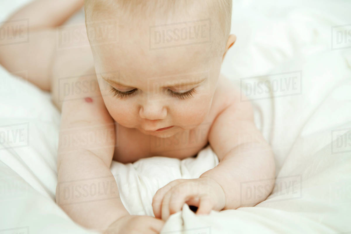 Baby contemplating blanket - Royalty-free Stock Photo | Dissolve