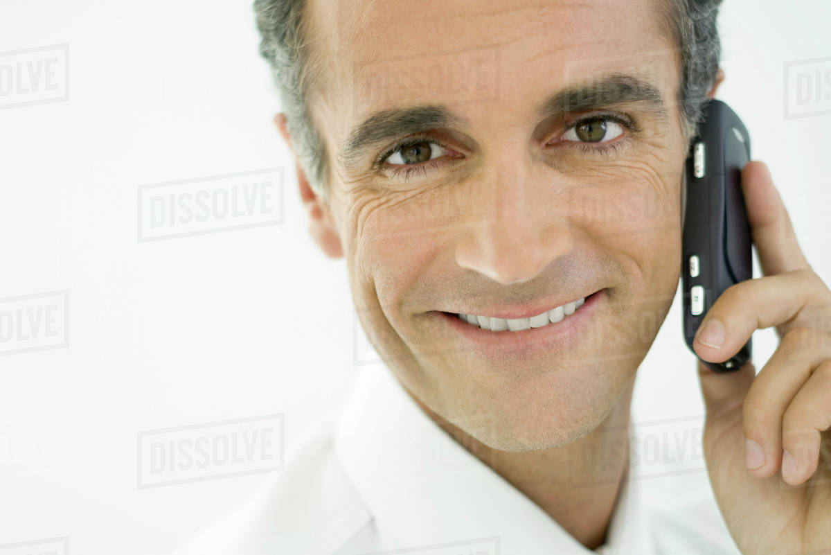 Man using cell phone, smiling at camera - Royalty-free Stock Photo ...