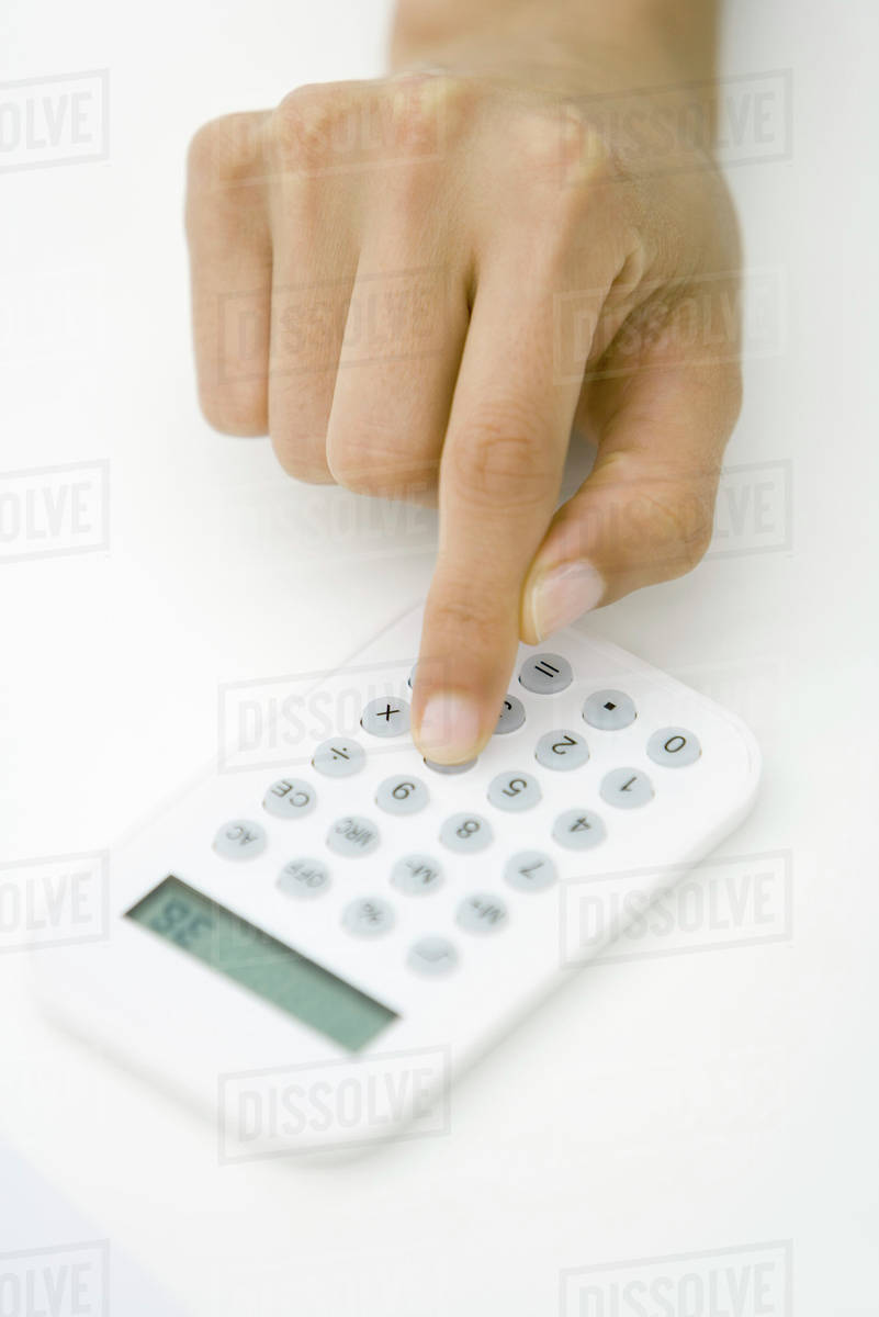 Person using calculator, cropped view of hand - Stock Photo - Dissolve