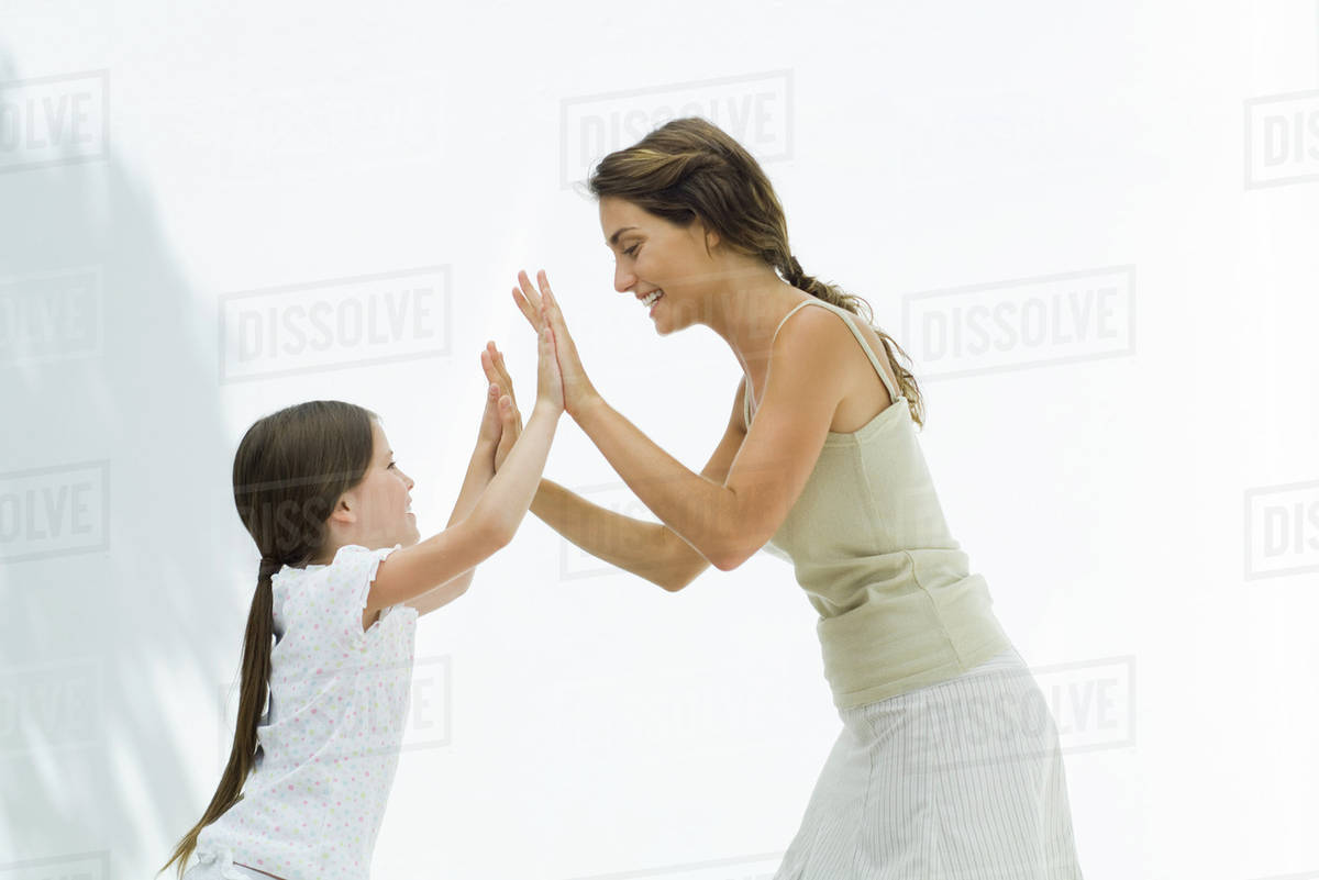 Mother and daughter playing clapping game together - Stock Photo - Dissolve