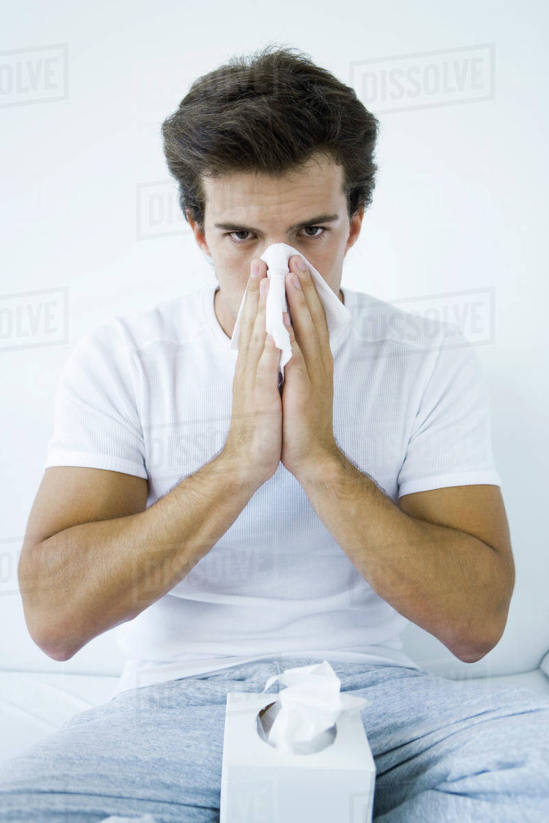 Man blowing his nose with a tissue, looking at camera - Stock Photo ...