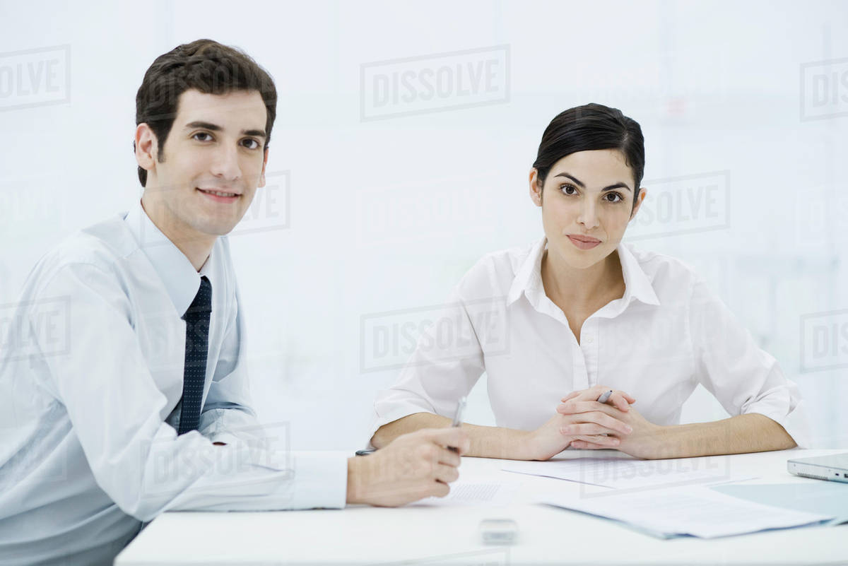 Professionals sitting with documents, smiling at camera - Royalty-free ...