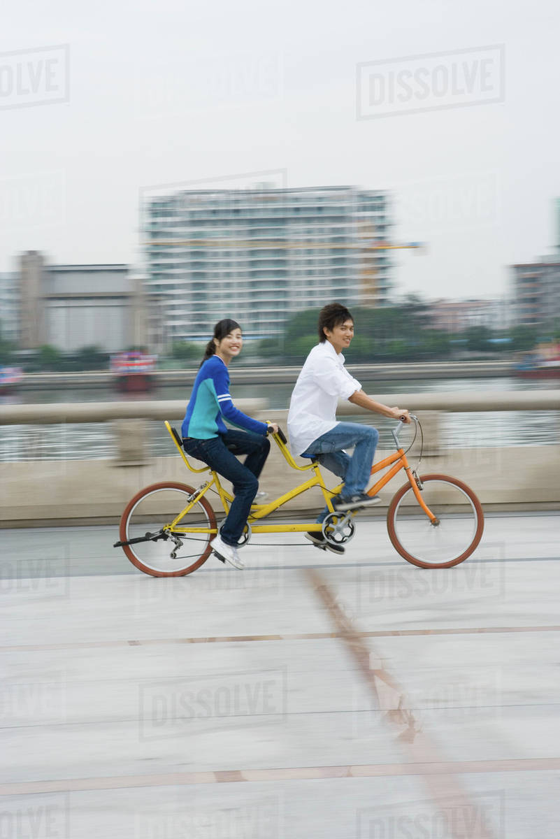 Young couple riding tandem bicycle - Royalty-free Stock Photo | Dissolve