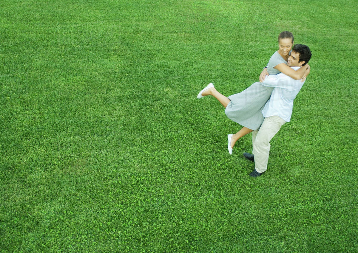 Man swinging woman in his arms, full length, high angle view - Stock ...