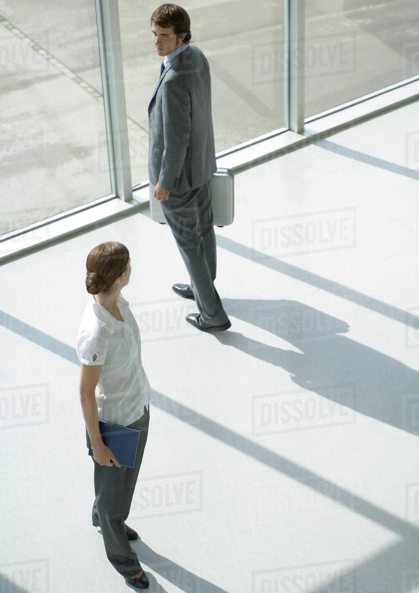 Man and woman looking over shoulders at each other, full length, high ...