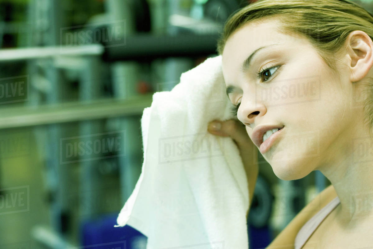 Young woman wiping forehead - Royalty-free Stock Photo | Dissolve