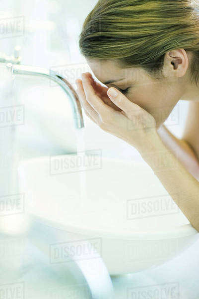 Woman washing face over sink - Royalty-free Stock Photo | Dissolve