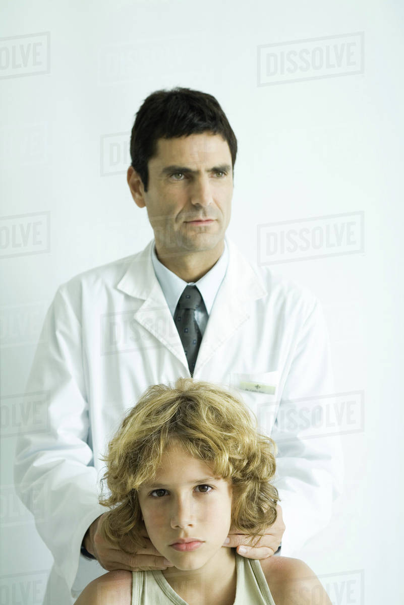Doctor feeling boy's neck - Royalty-free Stock Photo | Dissolve