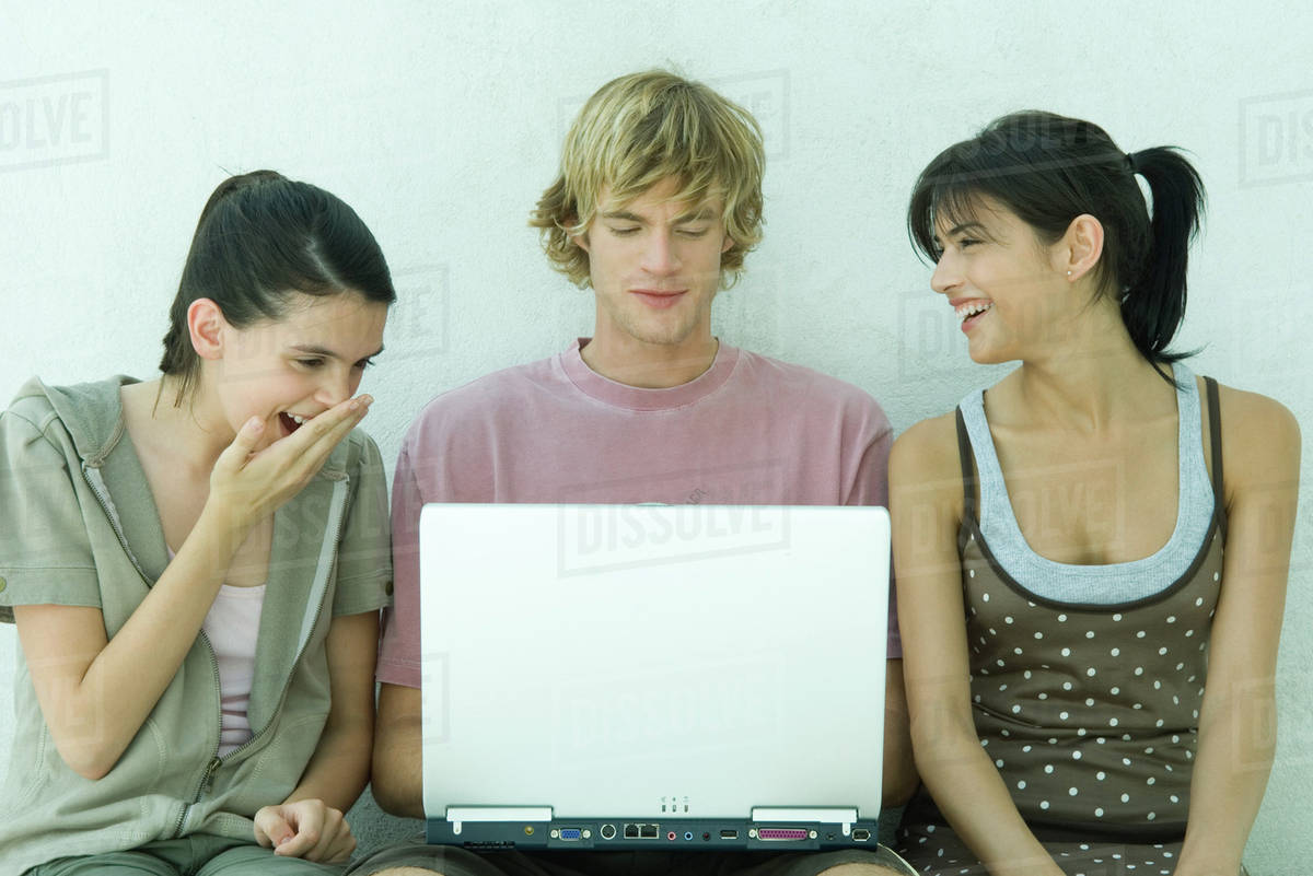 Group of young friends using laptop - Royalty-free Stock Photo | Dissolve