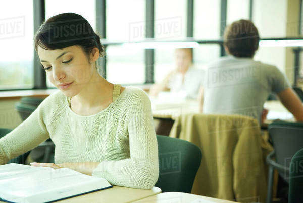 Female college student sitting at table in library, studying - Royalty ...