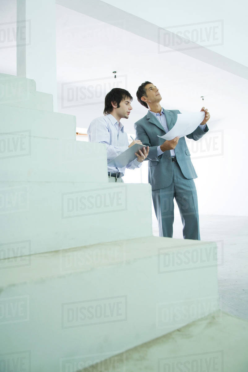 Two well-dressed men inspecting home interior - Royalty-free Stock ...