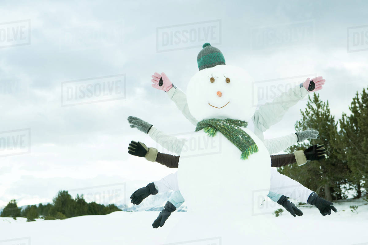 Young friends hiding behind snowman, arms outstretched - Royalty-free ...