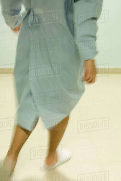 Patient running way in hospital corridor, cropped rear view, blurred ...