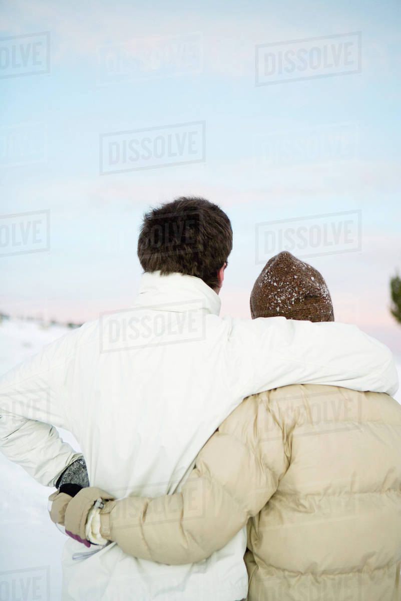 Two unrecognizable people standing together, embracing, dressed in ...