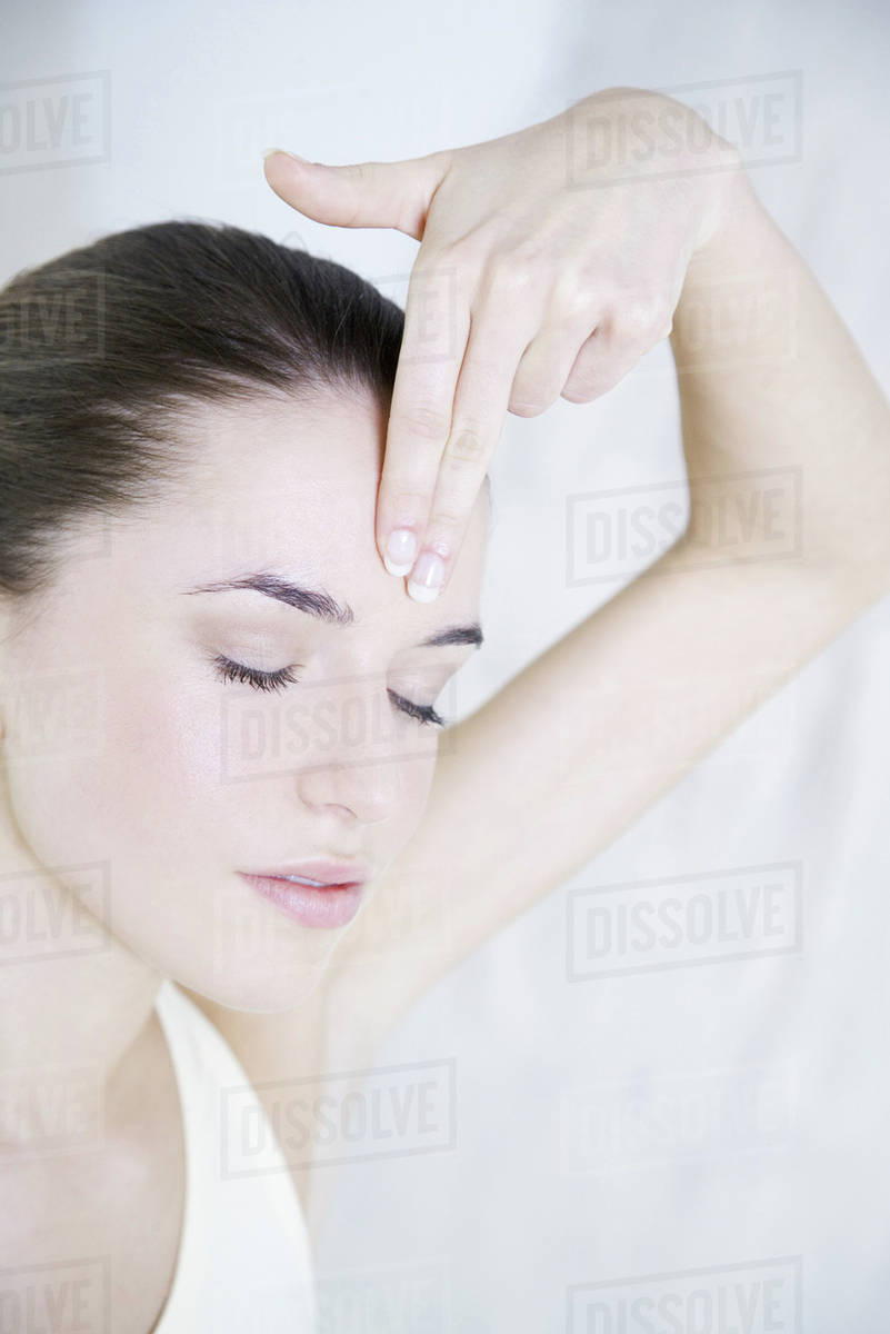 Young woman touching forehead, eyes closed - Royalty-free Stock Photo ...