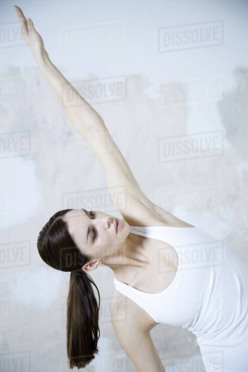 Woman stretching, one arm raised, looking up - Royalty-free Stock Photo ...