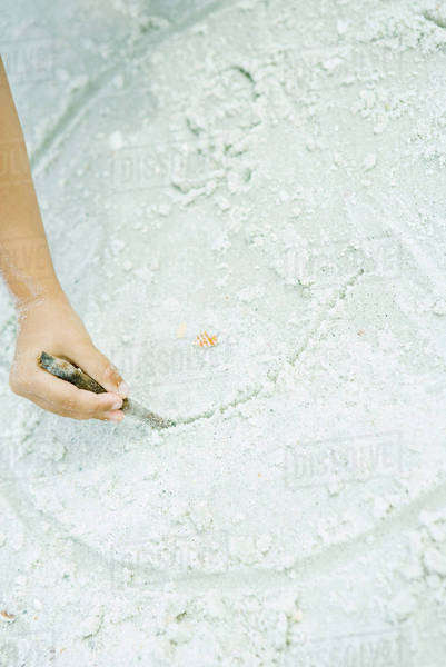 Child drawing in the sand with stick, cropped view of hand - Royalty ...