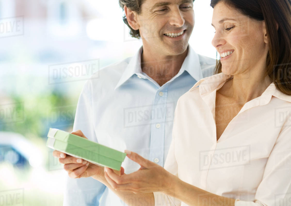 Mature couple, man handing woman gift - Royalty-free Stock Photo | Dissolve