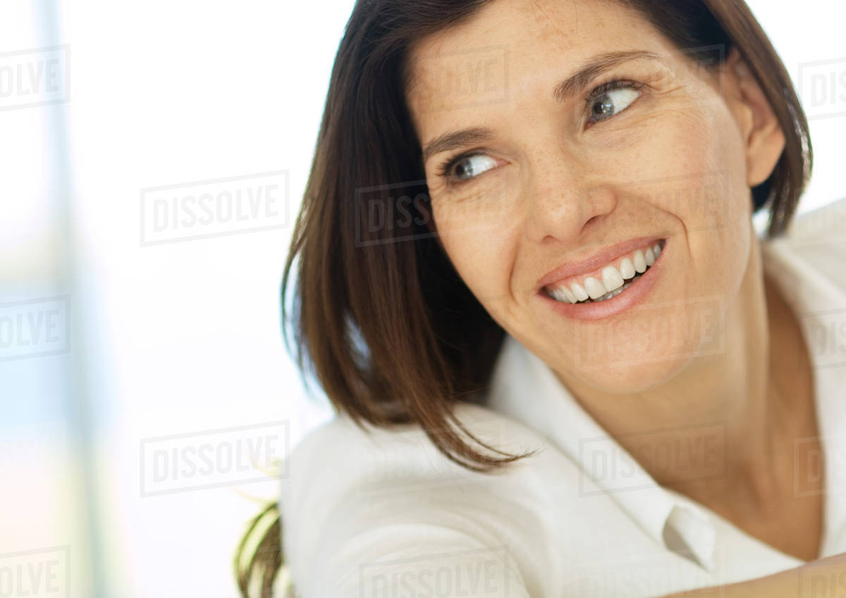 Mid-adult woman smiling, portrait - Stock Photo - Dissolve