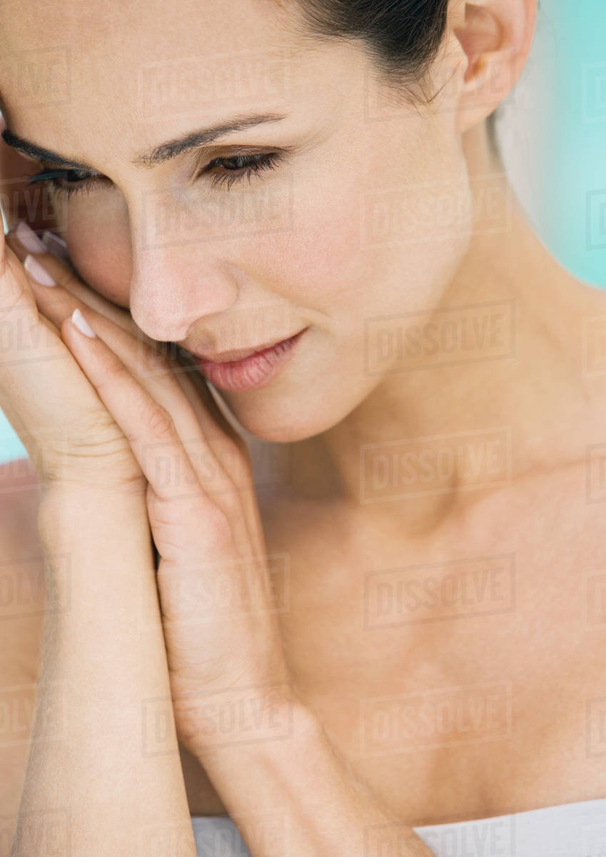 Woman resting face against hands - Royalty-free Stock Photo | Dissolve