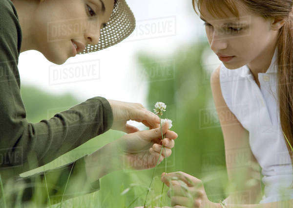Young woman and girl looking at flowers - Royalty-free Stock Photo ...