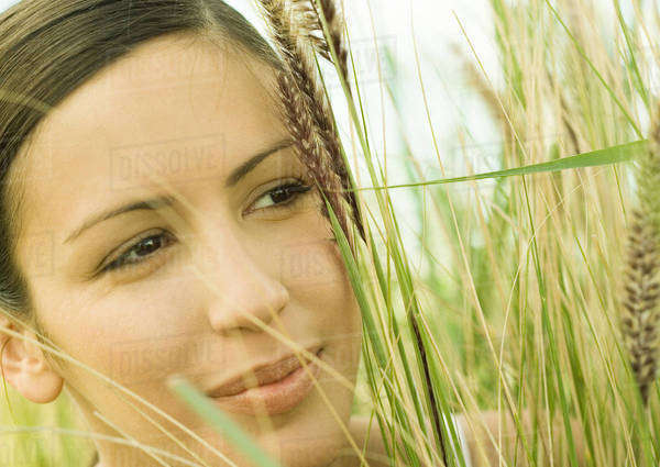 Woman's face in long grass - Stock Photo - Dissolve