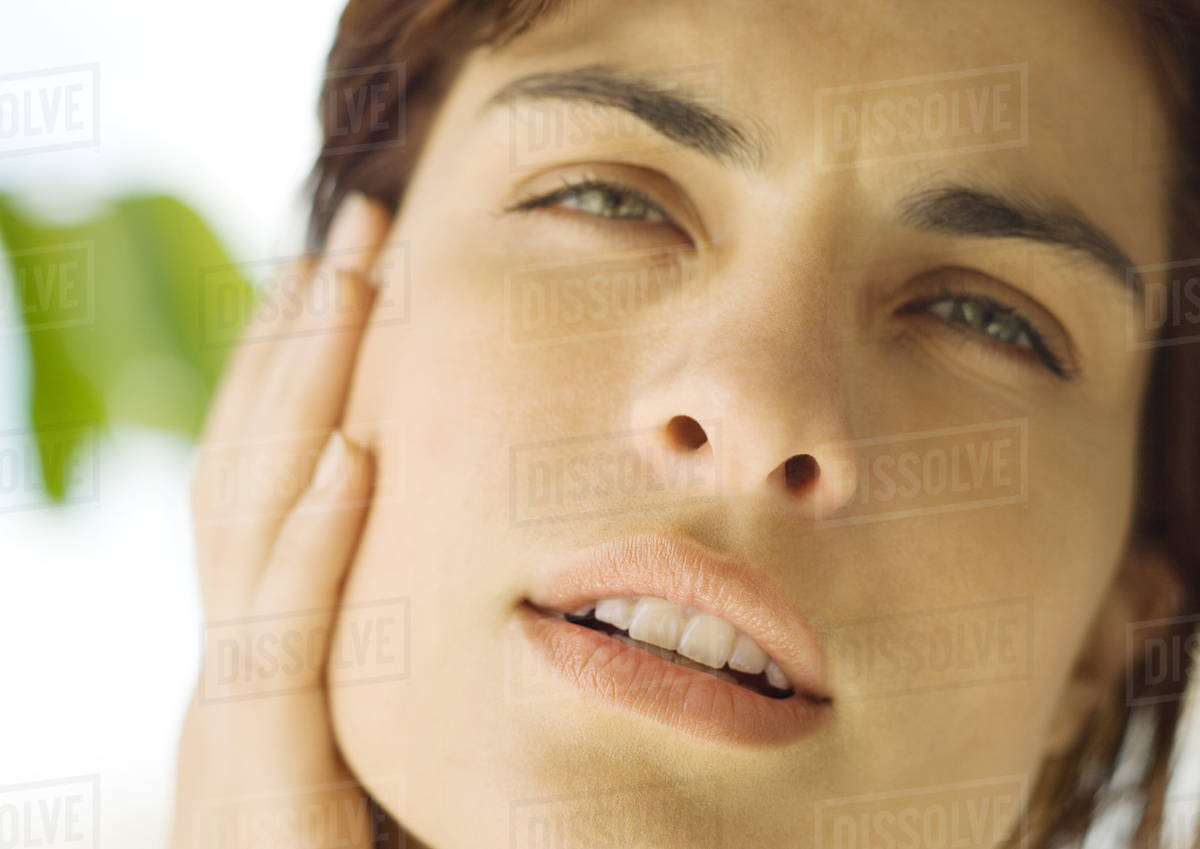 Woman's face with hand on cheek - Stock Photo - Dissolve