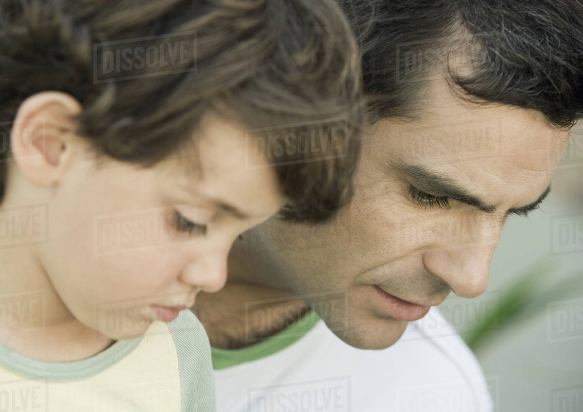 Father and son side by side and looking down together, side view ...