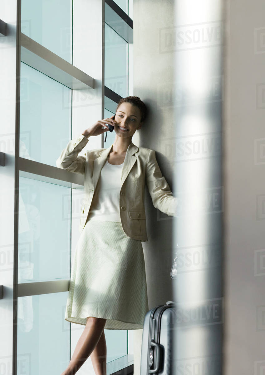 Female traveler using cell phone by window - Stock Photo - Dissolve