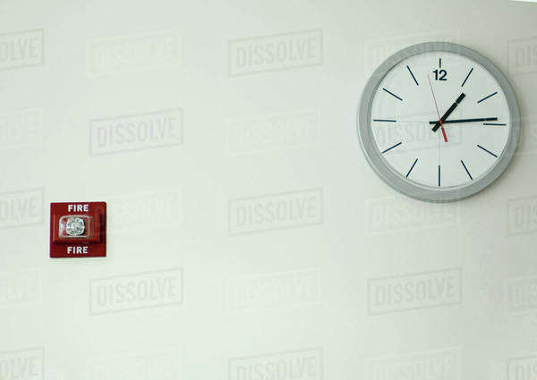 Clock and fire alarm on wall - Royalty-free Stock Photo | Dissolve