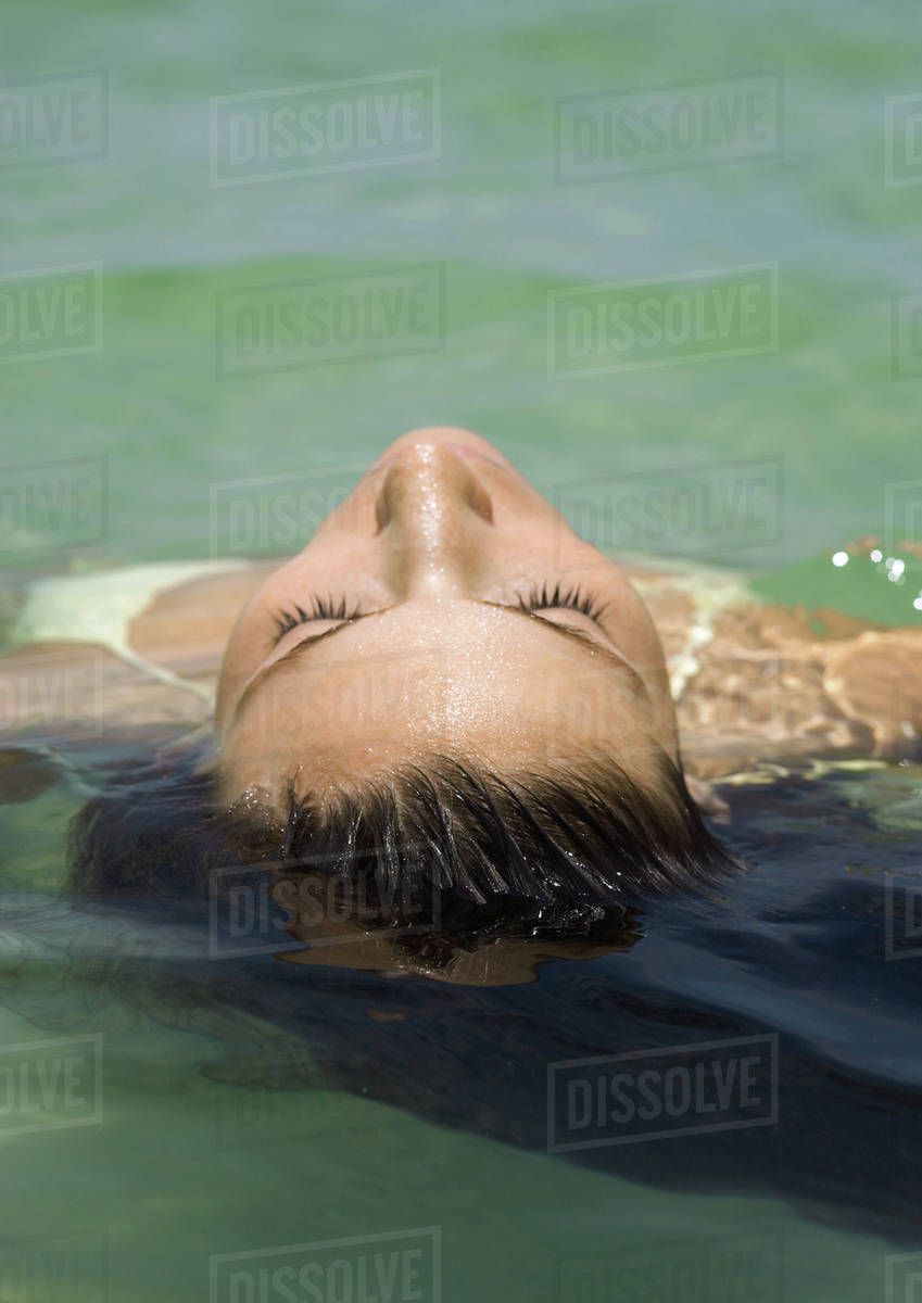 Woman floating in water - Stock Photo - Dissolve