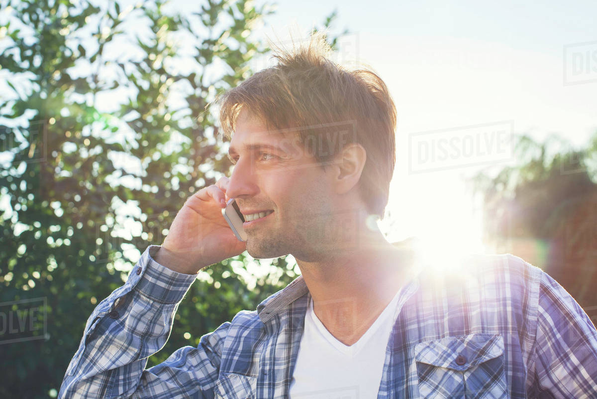 Man taking phone call on cell phone while enjoying being outdoors ...