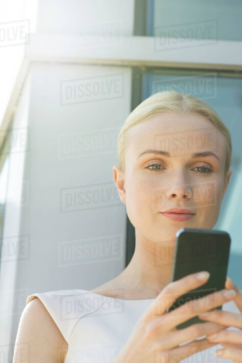 Woman looking at smartphone - Royalty-free Stock Photo | Dissolve