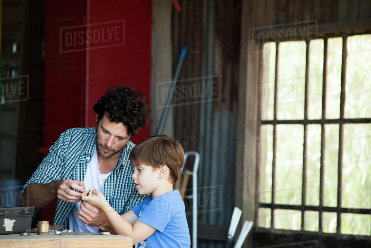 Child helping his father sort work materials - Stock Photo - Dissolve