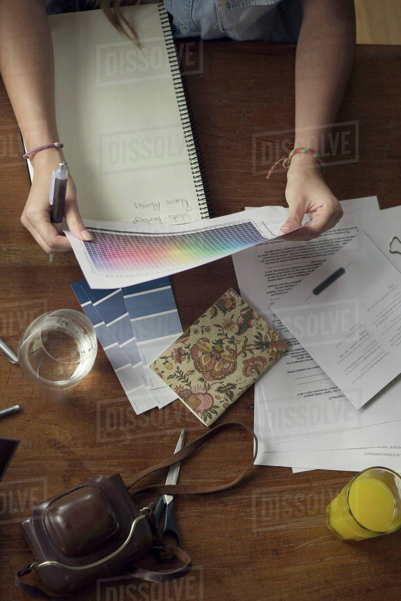 Woman looking at color spectrum sheet - Stock Photo - Dissolve