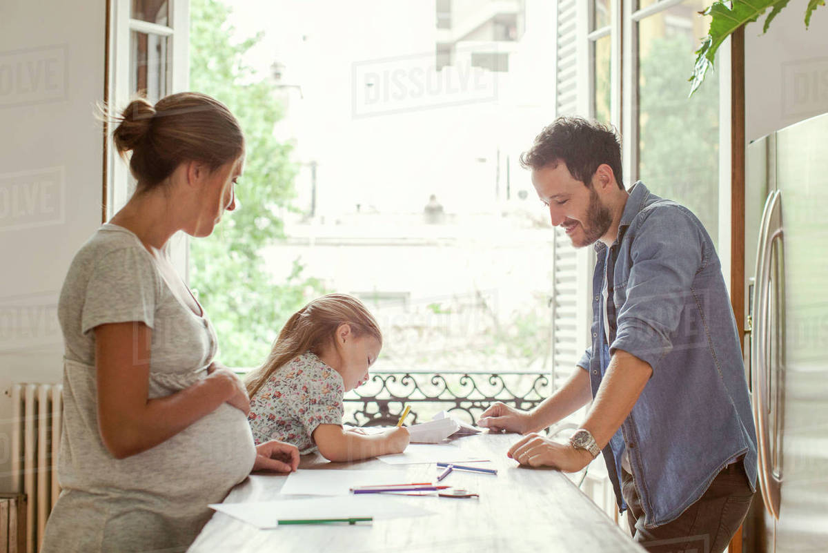 Parents watching as daughter colors - Royalty-free Stock Photo | Dissolve