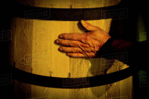 Hand touching wooden cask - Stock Photo - Dissolve