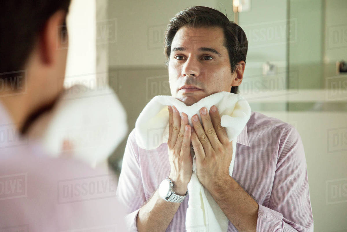 Man looking in mirror, drying his face with a towel - Royalty-free ...