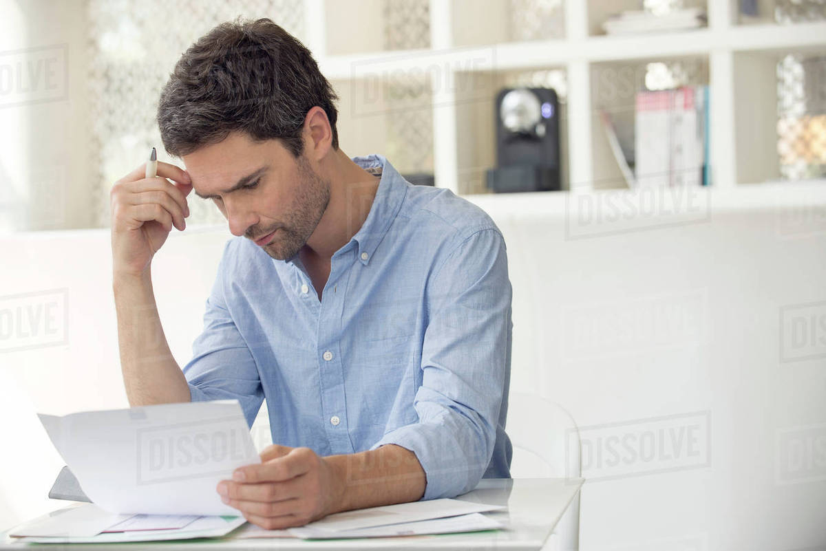 Man frustrated by mounting debt - Stock Photo - Dissolve