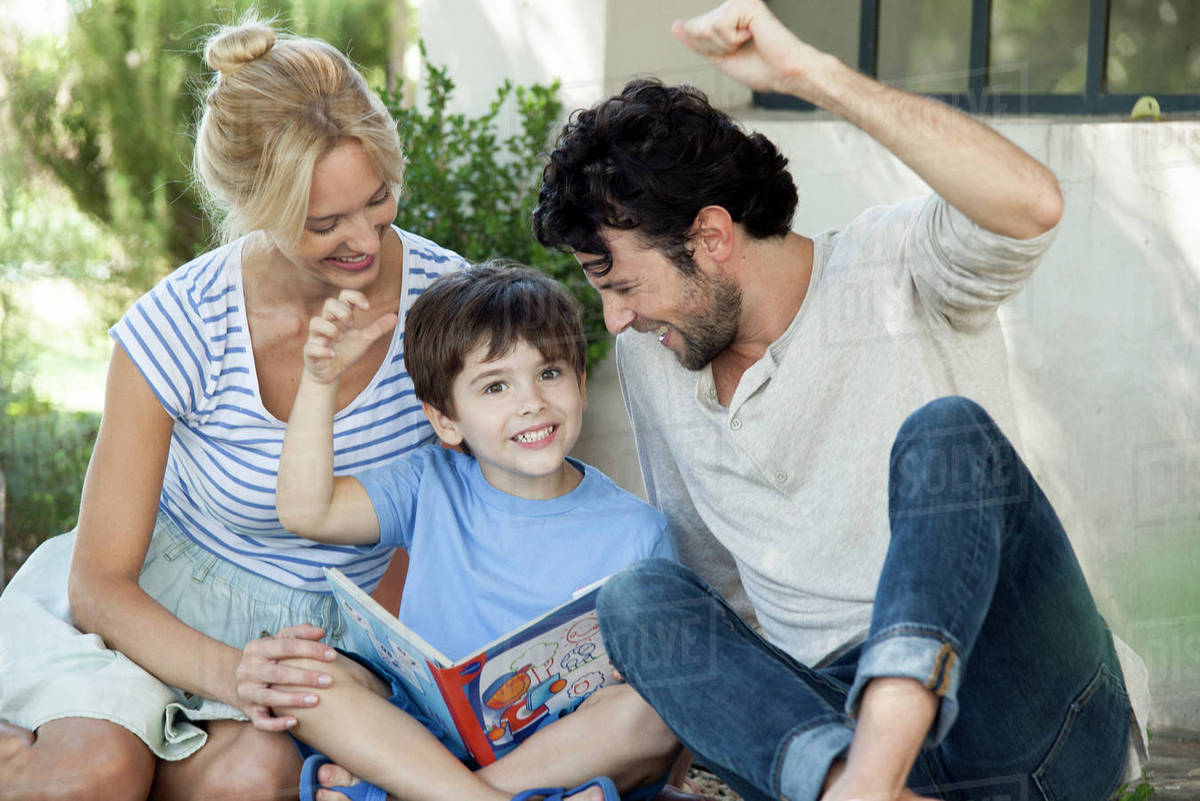 Parents teaching child to read - Royalty-free Stock Photo | Dissolve